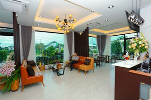 Um hall moderno de hotel com sofá, mesa de centro e área de refeições.