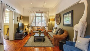 Sala de estar com televisão, sofá e mesa de centro.