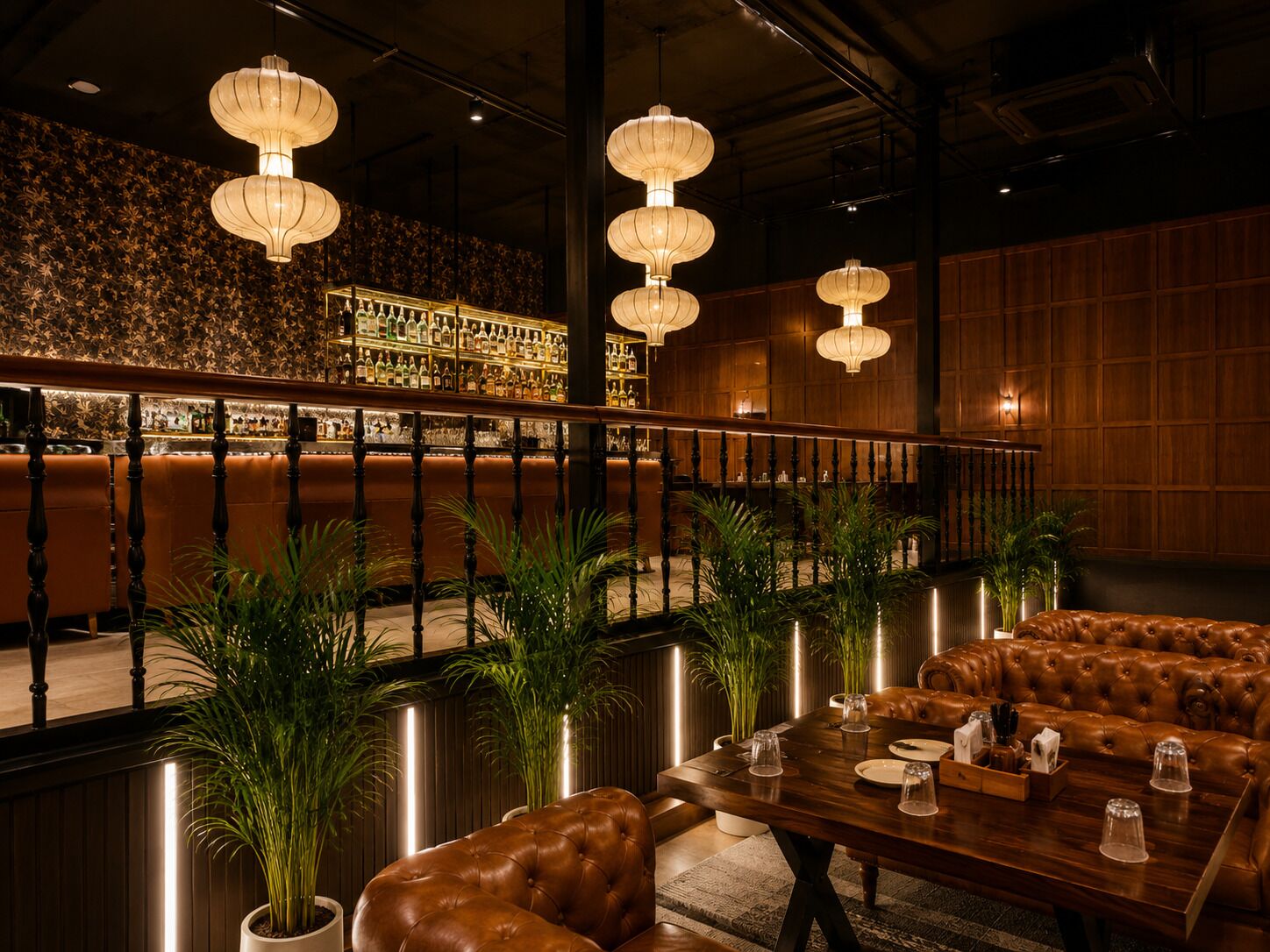 Uma área de bar com balcão de madeira, luminárias pendentes e assentos de couro.
