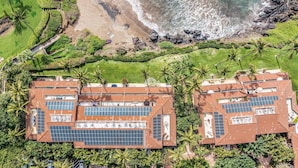 Resort com vários edifícios, painéis solares e uma praia.