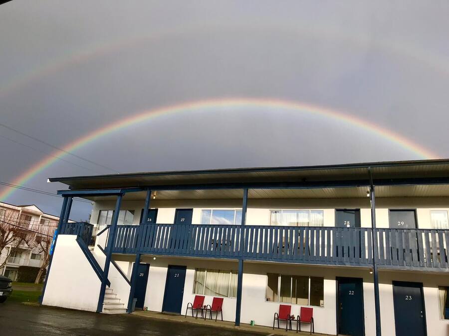 Um motel com varanda e quartos numerados.