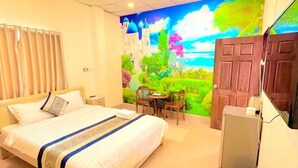 Quarto de hotel com cama, uma pequena mesa com cadeiras, uma porta e um mural na parede.