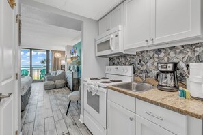 Estúdio com design assinado, 1 cama King e sofá-cama, sacada, vista para o oceano | Cozinha privada | Geladeira, micro-ondas, fogão, cooktop