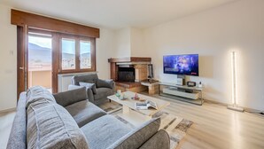 Uma sala de estar moderna com sofá, mesa de centro e lareira.