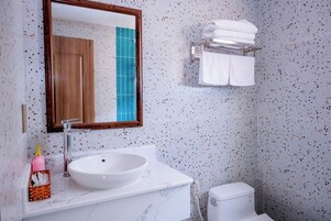 Quarto Triplo Deluxe, vista parcial para o oceano | Casa de banho | Um secador de cabelo, chinelos 