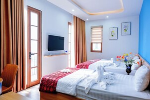 Quarto Triplo Deluxe, vista parcial para o oceano | Cofre no quarto, secretária 