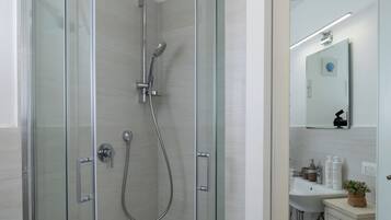 Apartamento, vista para o mar | Casa de banho | Um polibã, artigos de higiene pessoal grátis, um secador de cabelo