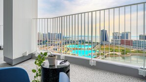 Varanda com vista para a paisagem urbana e uma piscina grande.