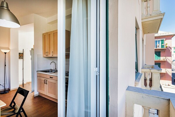 Um apartamento moderno com cozinha, sala de jantar e varanda com vista para a cidade.