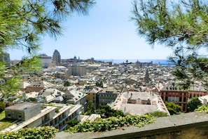 Vista panorâmica de um horizonte urbano com arquitetura histórica, uma igreja importante e uma costa ao fundo.