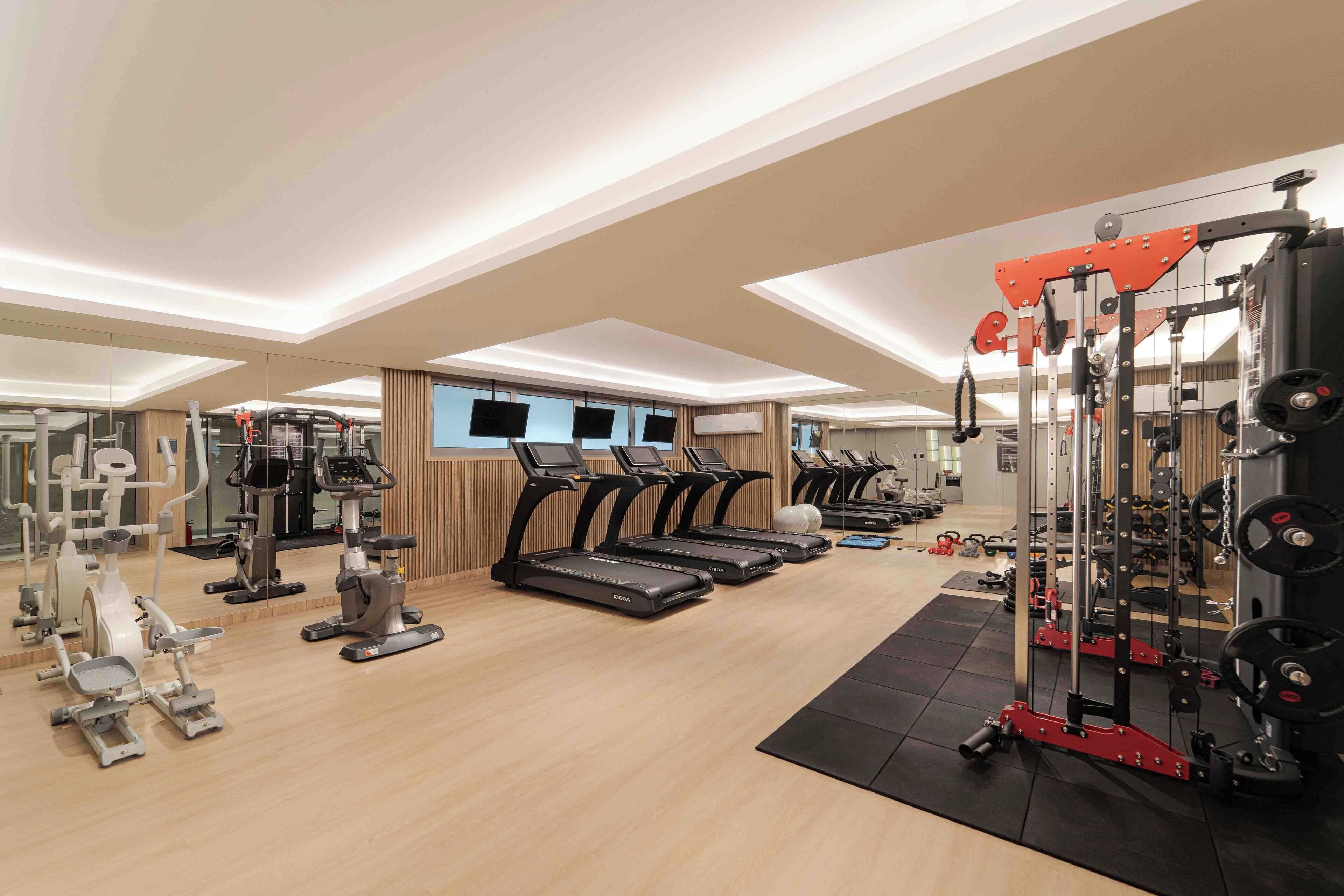 Academia moderna com esteiras, elípticos e equipamentos de musculação.