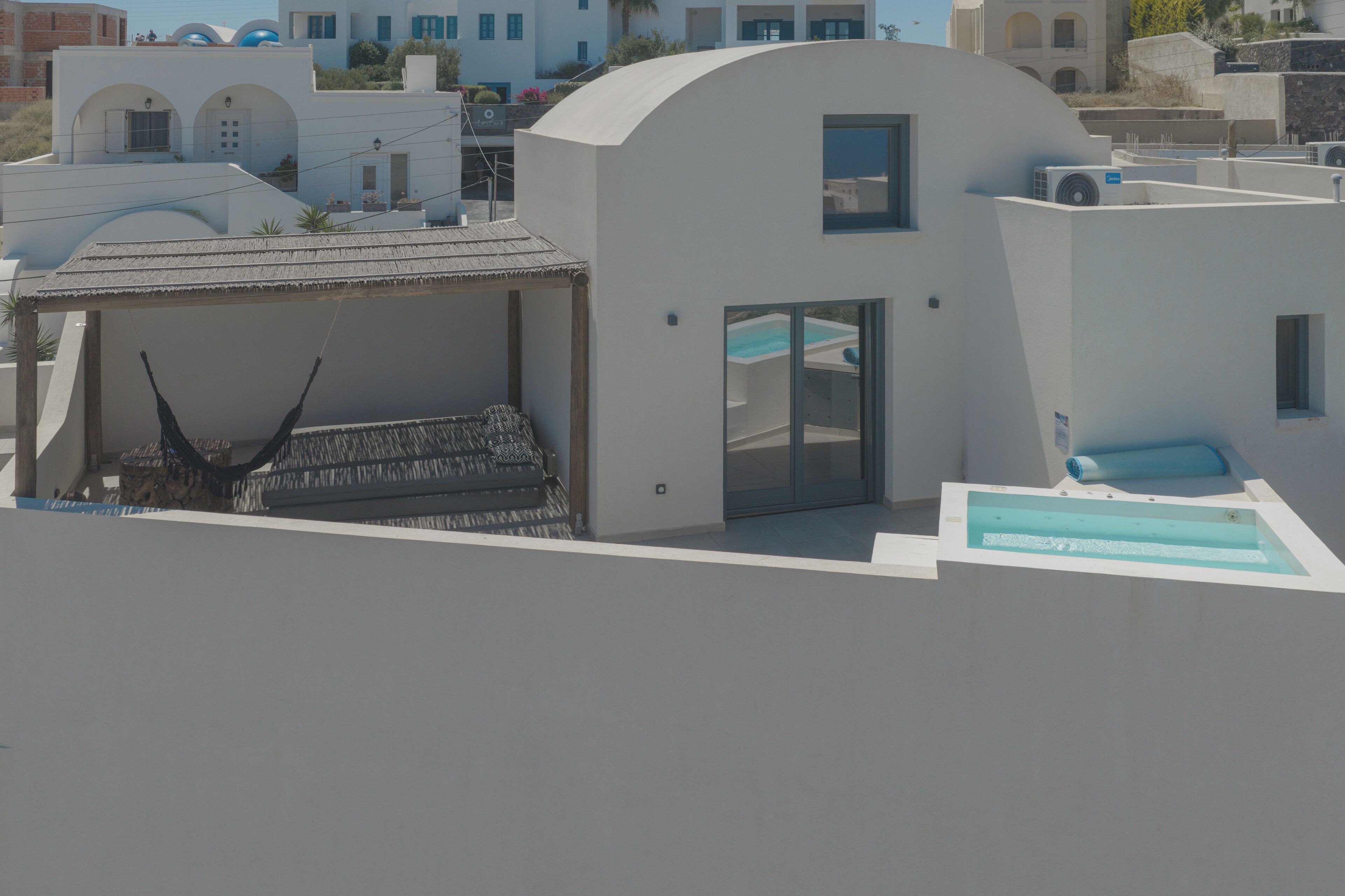 Um edifício moderno com área de estar coberta e piscina.