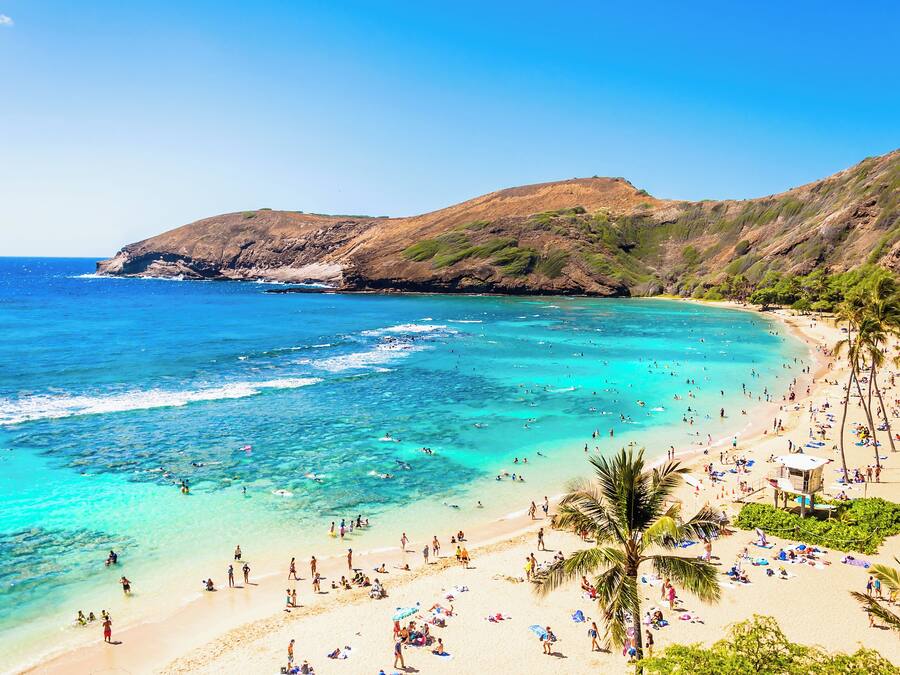 Perto da praia, areia branca, espreguiçadeiras, guarda-sóis