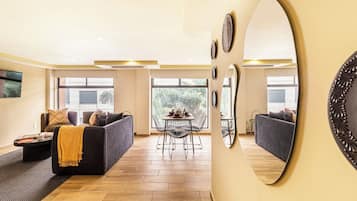 Apartamento Deluxe | Sala de estar | Smart TV de 50 polegadas com canais por cabo, serviços de streaming