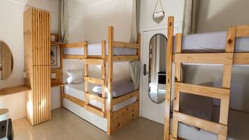 Quarto com beliches, guarda-roupa de madeira, espelho e porta com número.