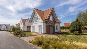 Uma casa de dois andares com telhado íngreme e fachada de tijolos.