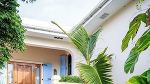 Escada com corrimãos brancos que leva à entrada de uma casa.