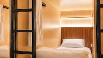 Quarto com beliche, cabeceira de madeira, escada e mesa de cabeceira.