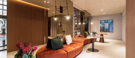Um interior moderno com uma área de estar curva, uma mesa de jantar e iluminação pendente.