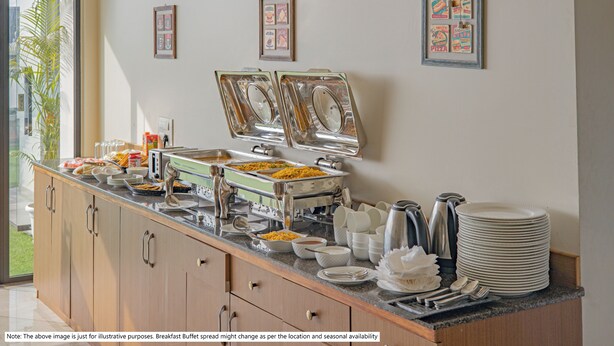 Disposição de buffet de café da manhã com diversos alimentos e utensílios.