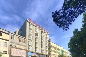 Um edifício de vários andares com uma placa de destaque no topo.