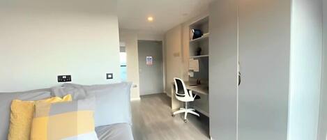 Um quarto moderno com uma cama, uma escrivaninha e um guarda-roupa.