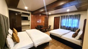 Quarto com duas camas, uma escrivaninha e uma cadeira.