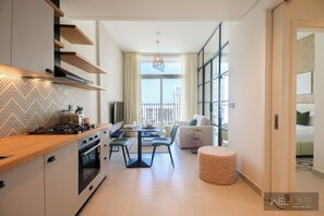 Um frigorífico, um forno, uma placa de cozinha, uma cafeteira/bule 