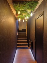 Uma escadaria com design moderno, apresentando uma parede escura e uma porta com a inscrição "La family".