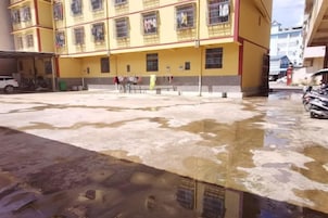 Um edifício amarelo de vários andares com um pátio.