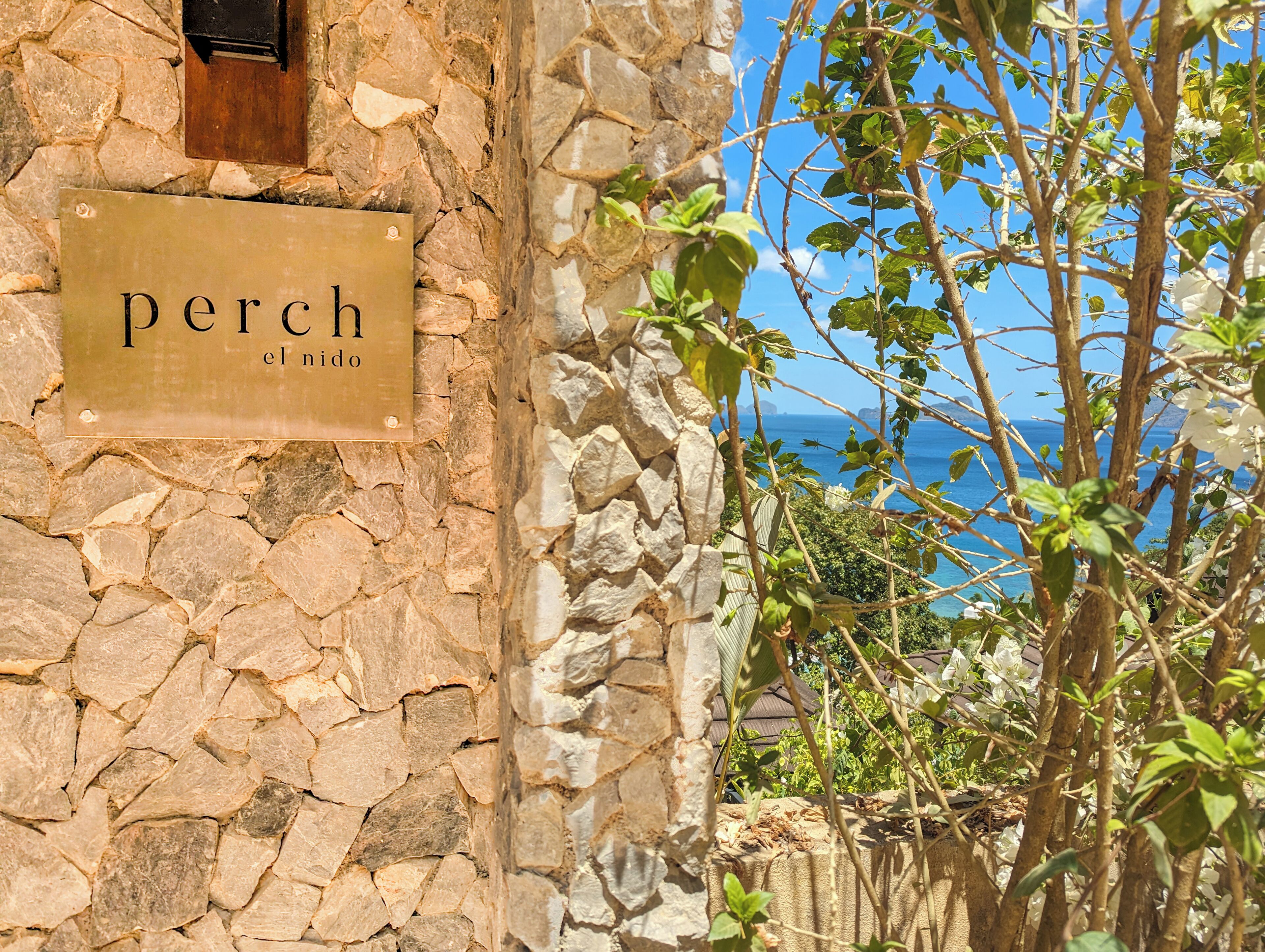 Mural de pedra com uma placa que diz 'perch el nido'.
