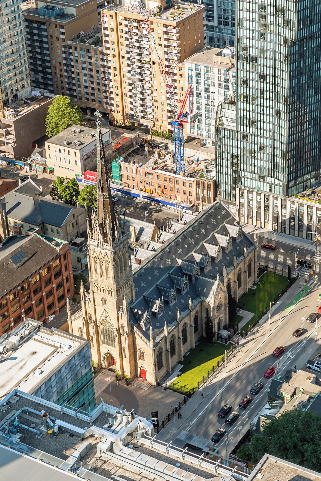 Um edifício histórico com uma torre imponente, cercado por edifícios modernos e altos.
