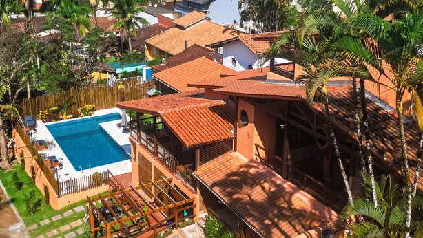 Zona residencial com piscina, casas escalonadas e vista para o mar.
