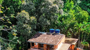 Uma casa de dois andares com piscina, área de estar externa e jardim.