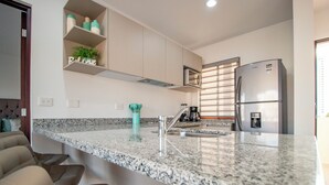 Uma cozinha moderna com bancada de granito, eletrodomésticos de aço inoxidável e forno embutido.