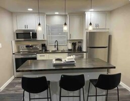 Minifrigorífico, uma placa de cozinha, utensílios de cozinha 