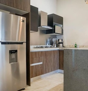 Apartamento luxo, vista para a cidade | Cozinha privada | Geladeira, micro-ondas, cooktop, talheres/pratos/utensílios de cozinha