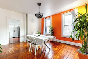 Uma área de refeições com uma mesa, cadeiras e um lustre.