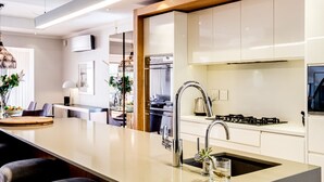 Uma cozinha moderna com uma ilha grande, eletrodomésticos de aço inoxidável e design minimalista.