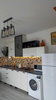 Uma cozinha moderna com máquina de lavar embutida, micro-ondas e fogão a gás.
