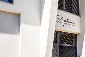 Fachada de um edifício com uma placa indicando "Ventini LOFTS".