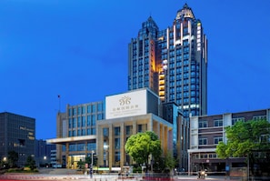 Um edifício moderno com uma placa de destaque para 'Polton International Service Apartment'.