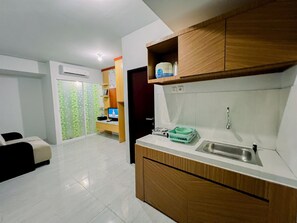 Apartamento Deluxe | Cozinha privada | Um frigorífico/congelador grande, uma placa de cozinha, mesas de jantar