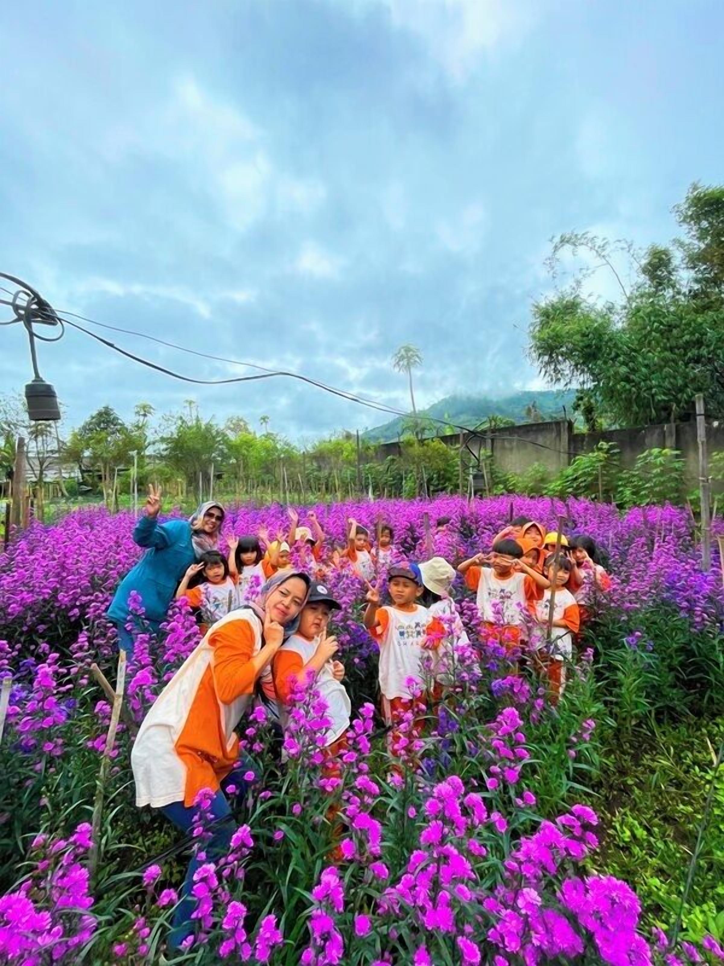 Um grupo de pessoas em um campo de flores roxas.
