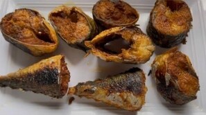 Uma travessa de peixe frito com pele chamuscada.