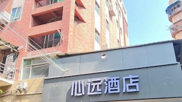 Placa de hotel com caracteres chineses, indicando o nome do estabelecimento.