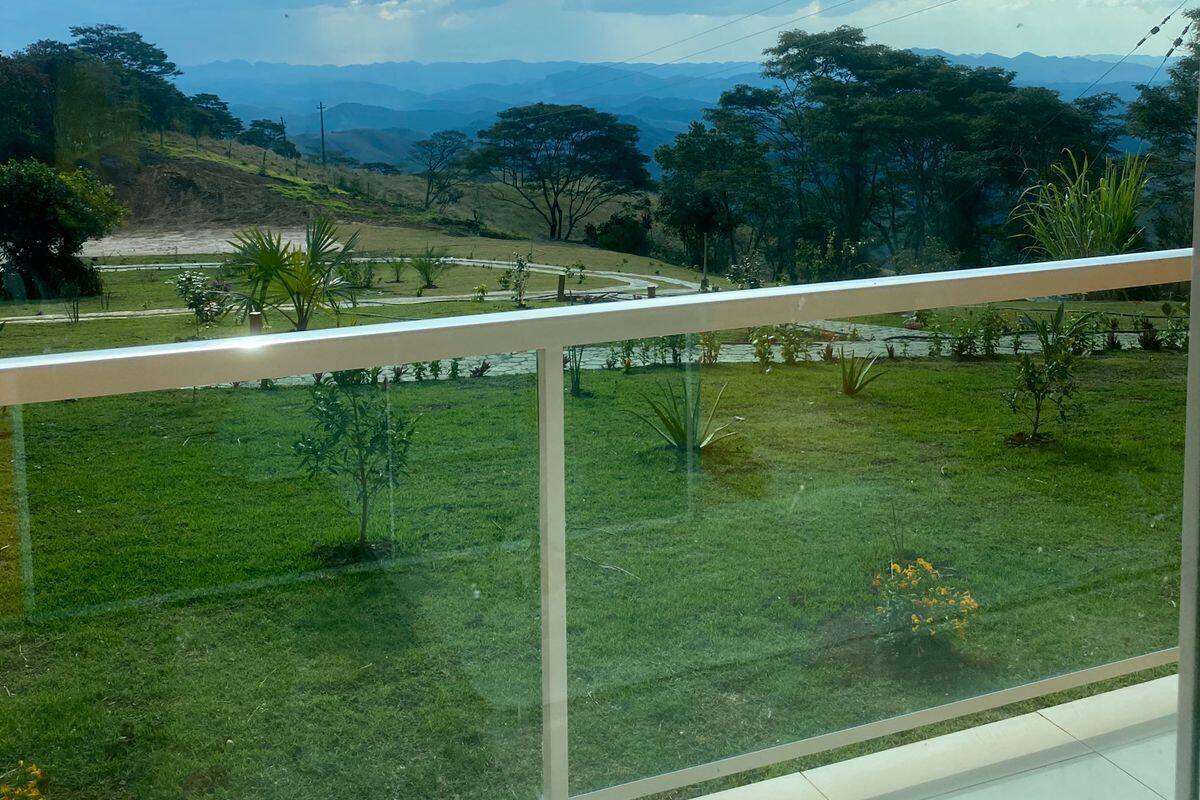 Uma varanda com vista para uma paisagem verde e montanhas ao longe.