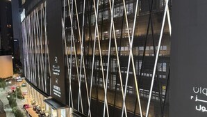 Um edifício moderno com fachada geométrica singular e uma placa indicando que se trata de um hotel.