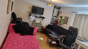 Um espaço compacto com cama, sofá, escrivaninha e cadeira.