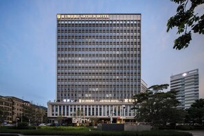 Edifício moderno do Arthur Hotel, com placa de destaque, vários andares e fachada plana.